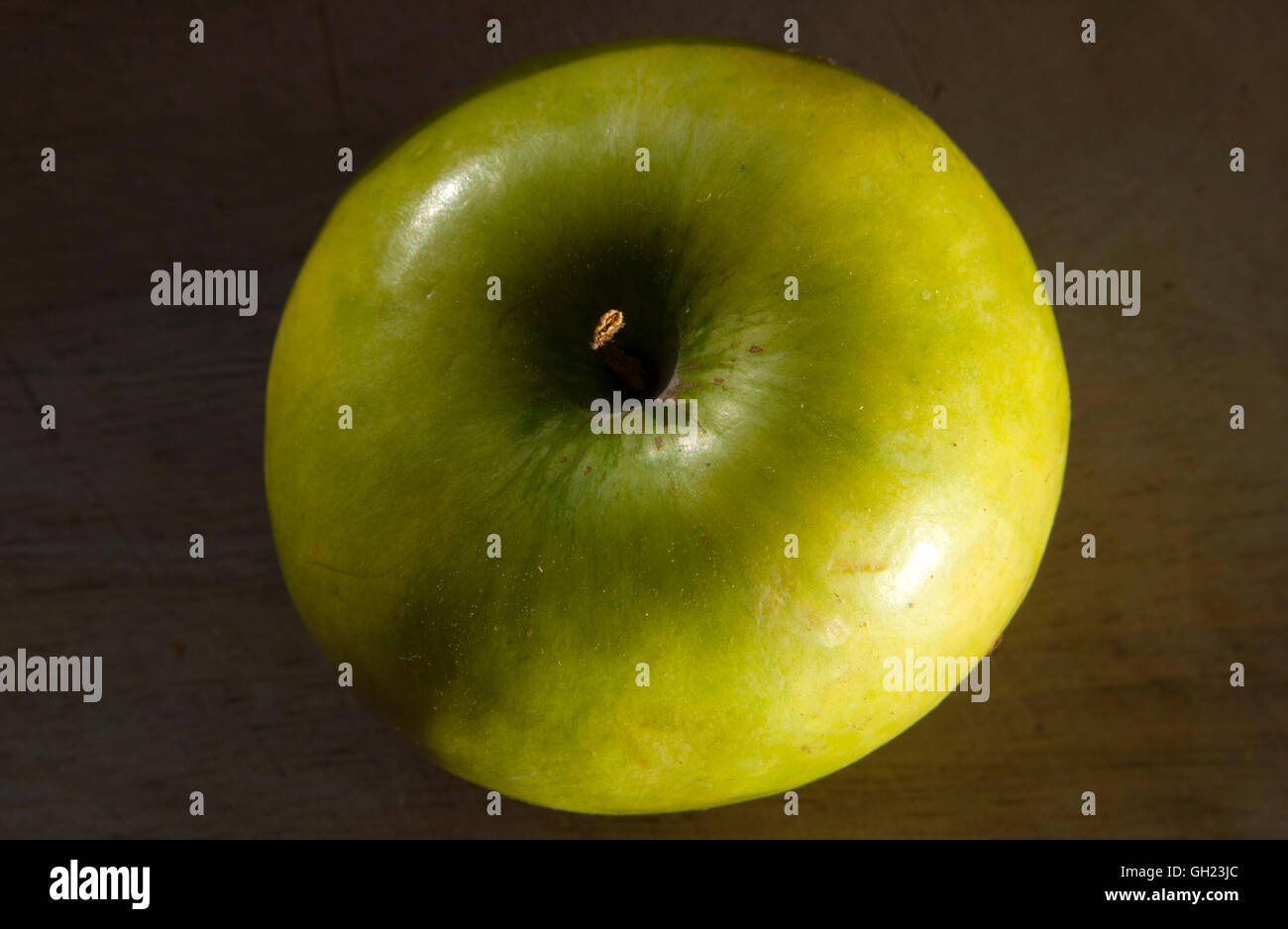 A round green apple on the wooden background Stock Photo - Alamy