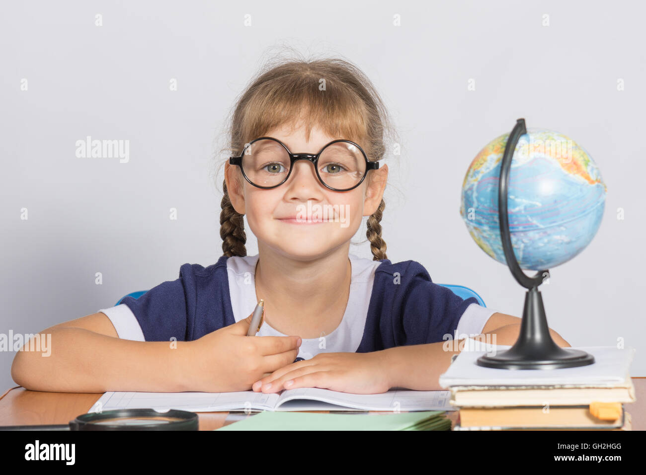 Happy girl first grader sits at a table Stock Photo - Alamy