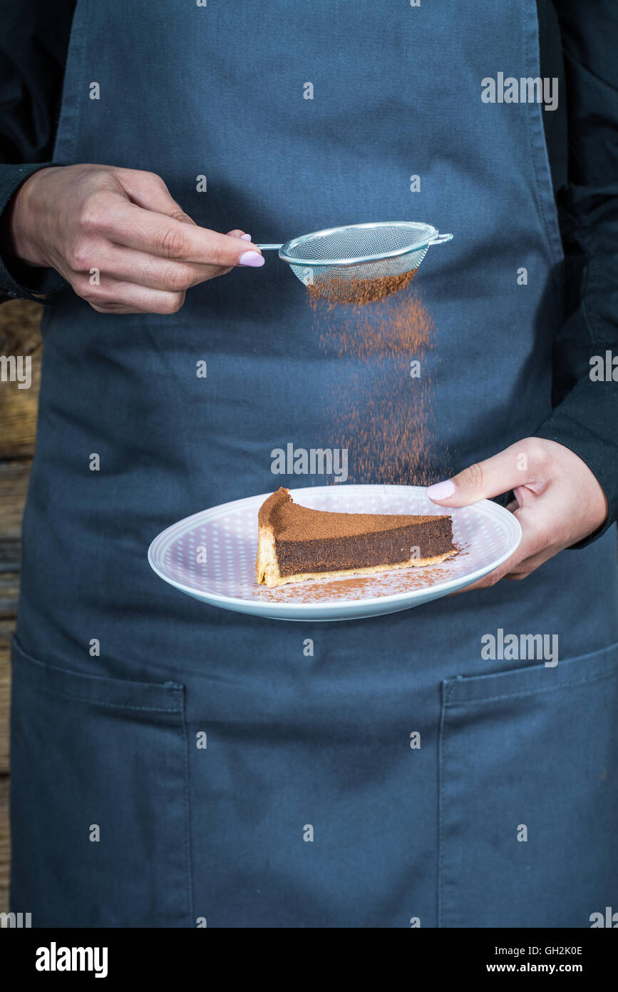 waitress serving chocolate cake with cocoa Stock Photo - Alamy