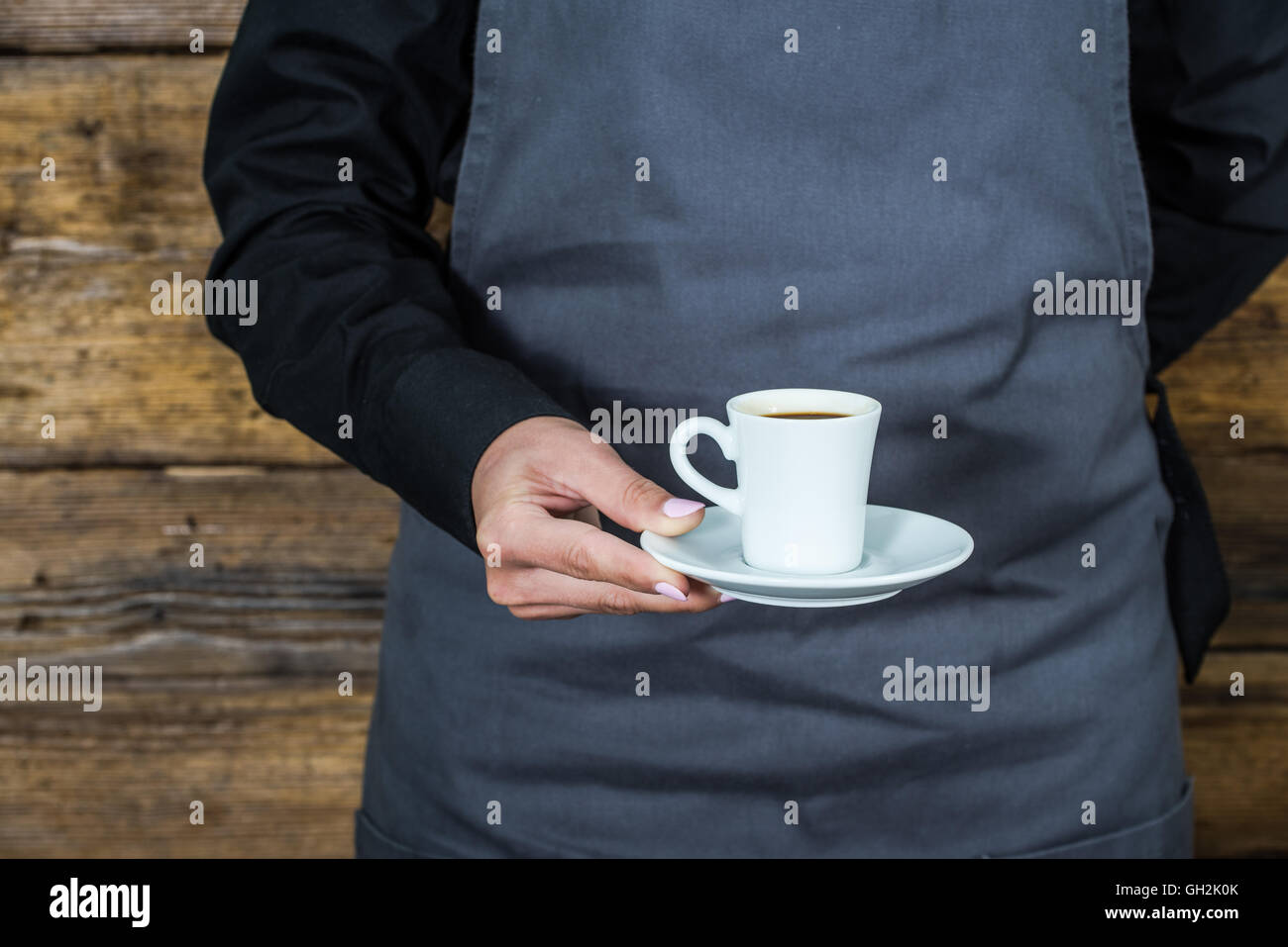 waitress offering espresso coffee wearing apron Stock Photo - Alamy