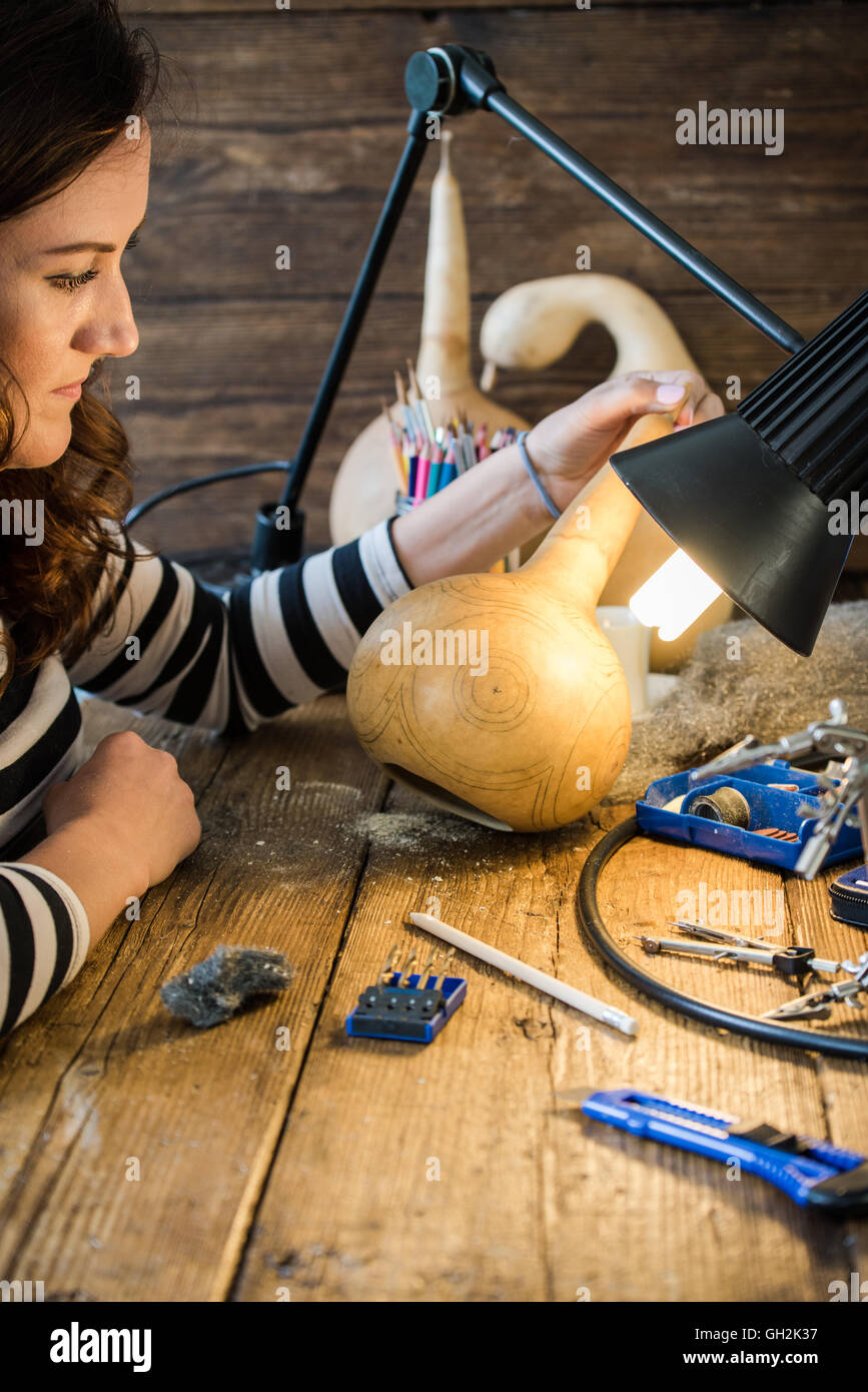 young woman concentrate on hobby creative craft in small local workshop ...