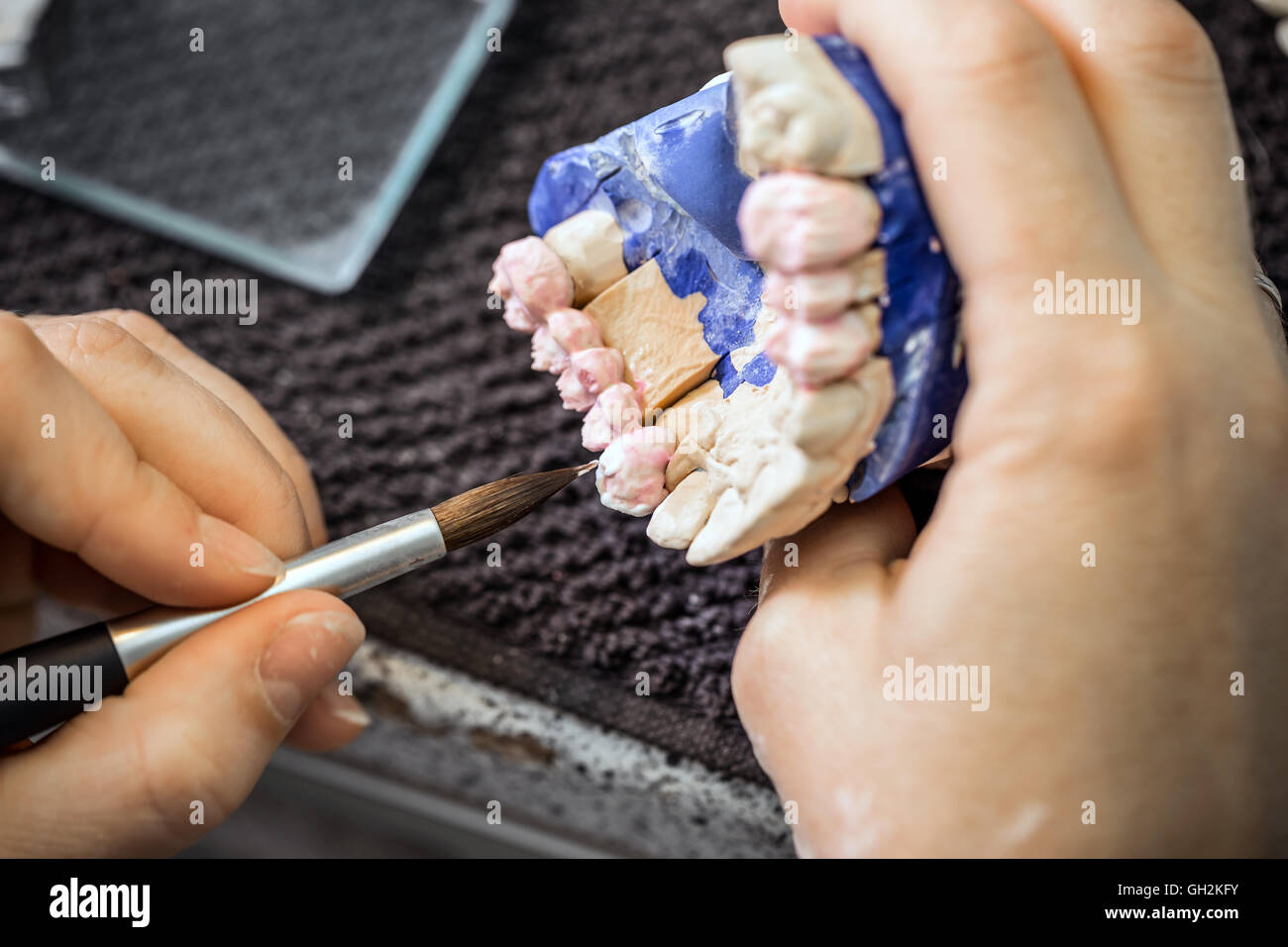 Dental technician working with tooth dentures at prosthesis laboratory ...