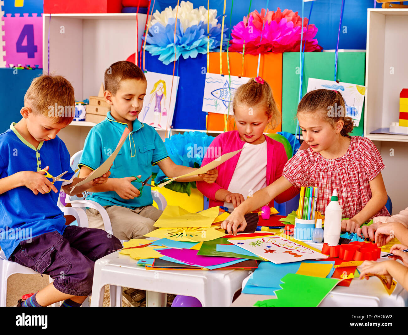 Children with teacher are making something out of colored paper Stock ...