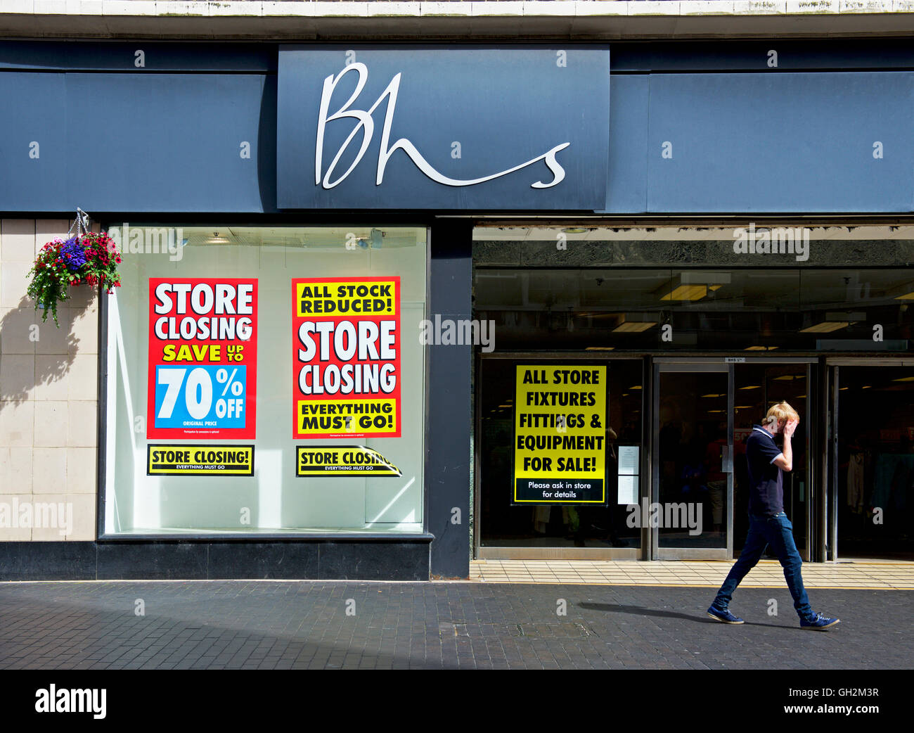 Young walking past branch of BHS, British Home Stores, holding closing ...