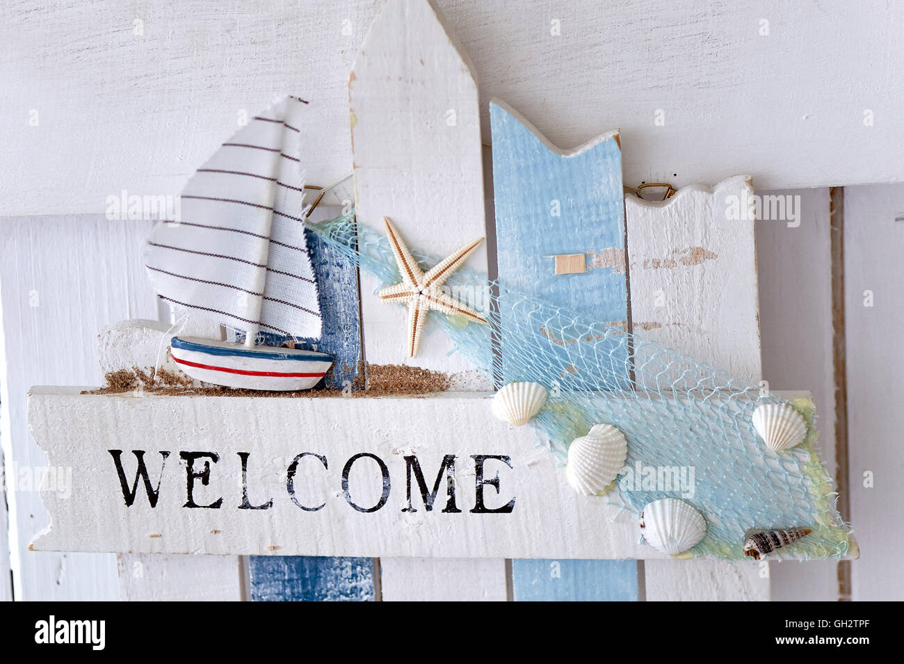 A sign in a marine style, with the word welcome, and a blue boat Stock ...