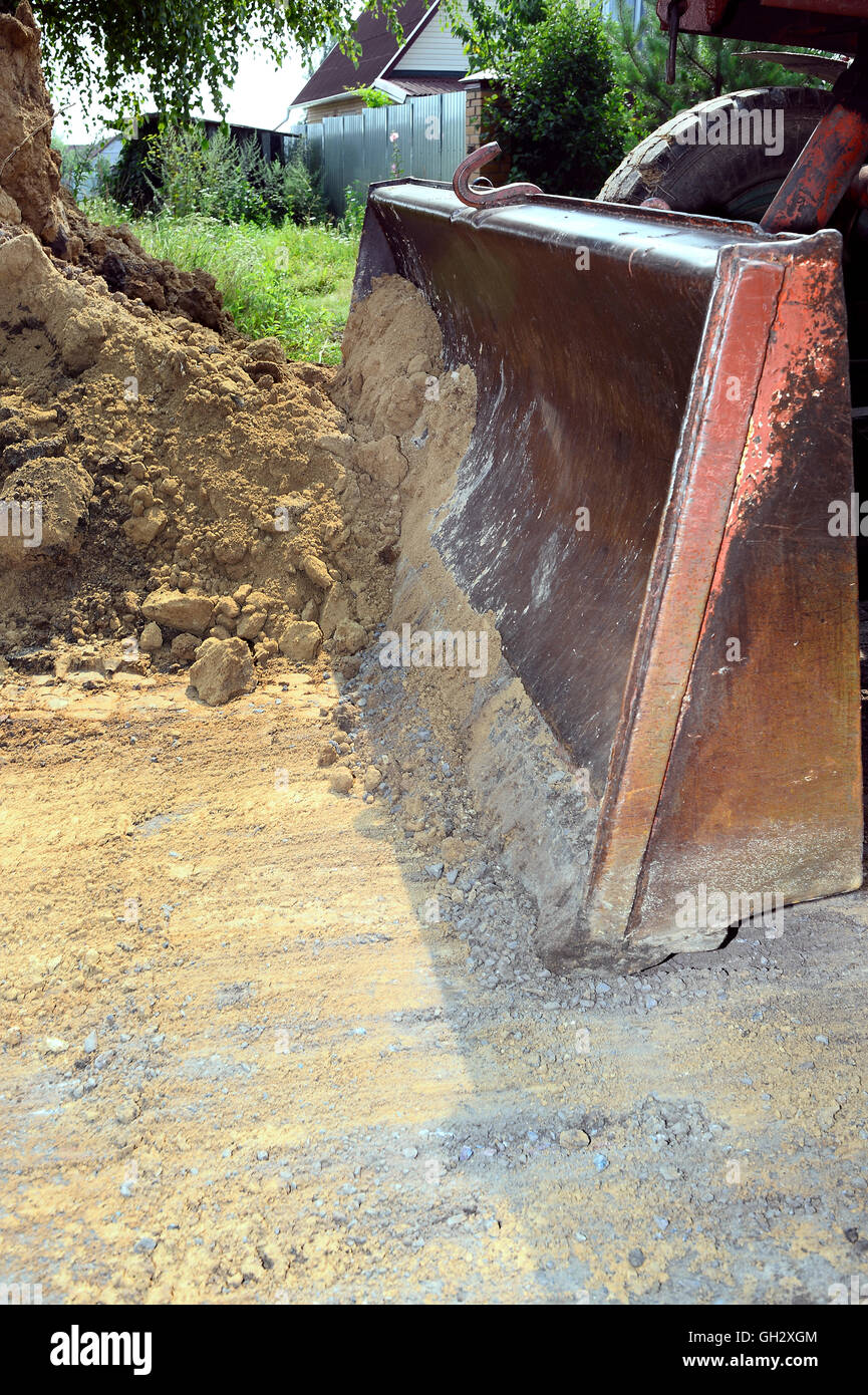 Excavator bucket digging a trench in the dirt ground Stock Photo - Alamy