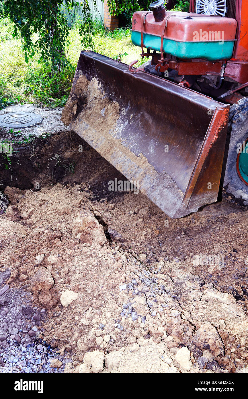 Excavator bucket digging a trench in the dirt ground Stock Photo - Alamy