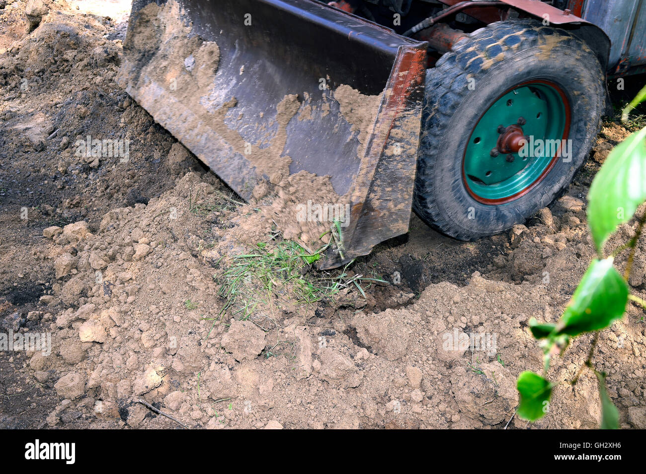 Excavator bucket digging a trench in the dirt ground Stock Photo - Alamy