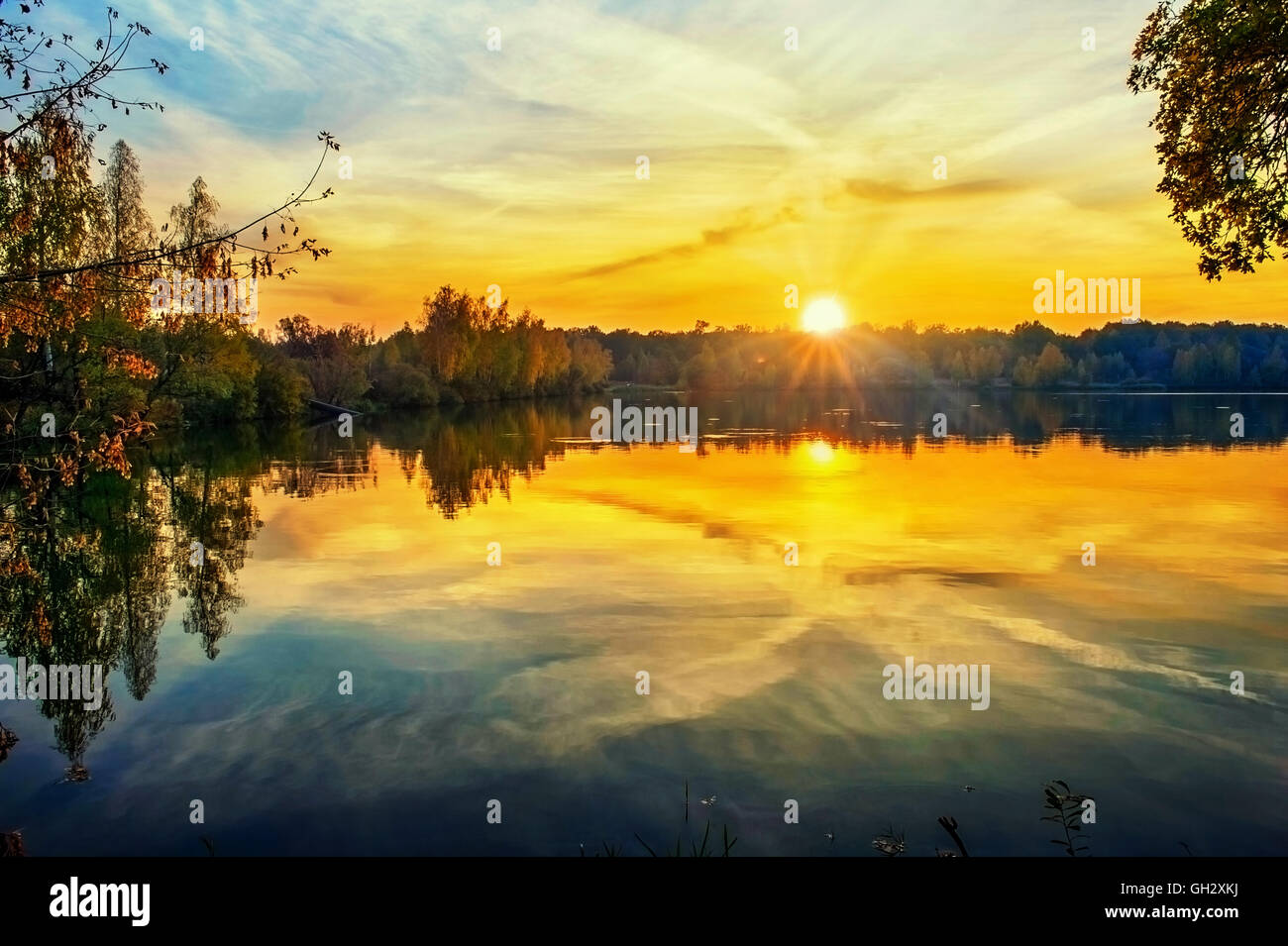 Autumn sunset on the lake with reflection of sun in water Stock Photo ...