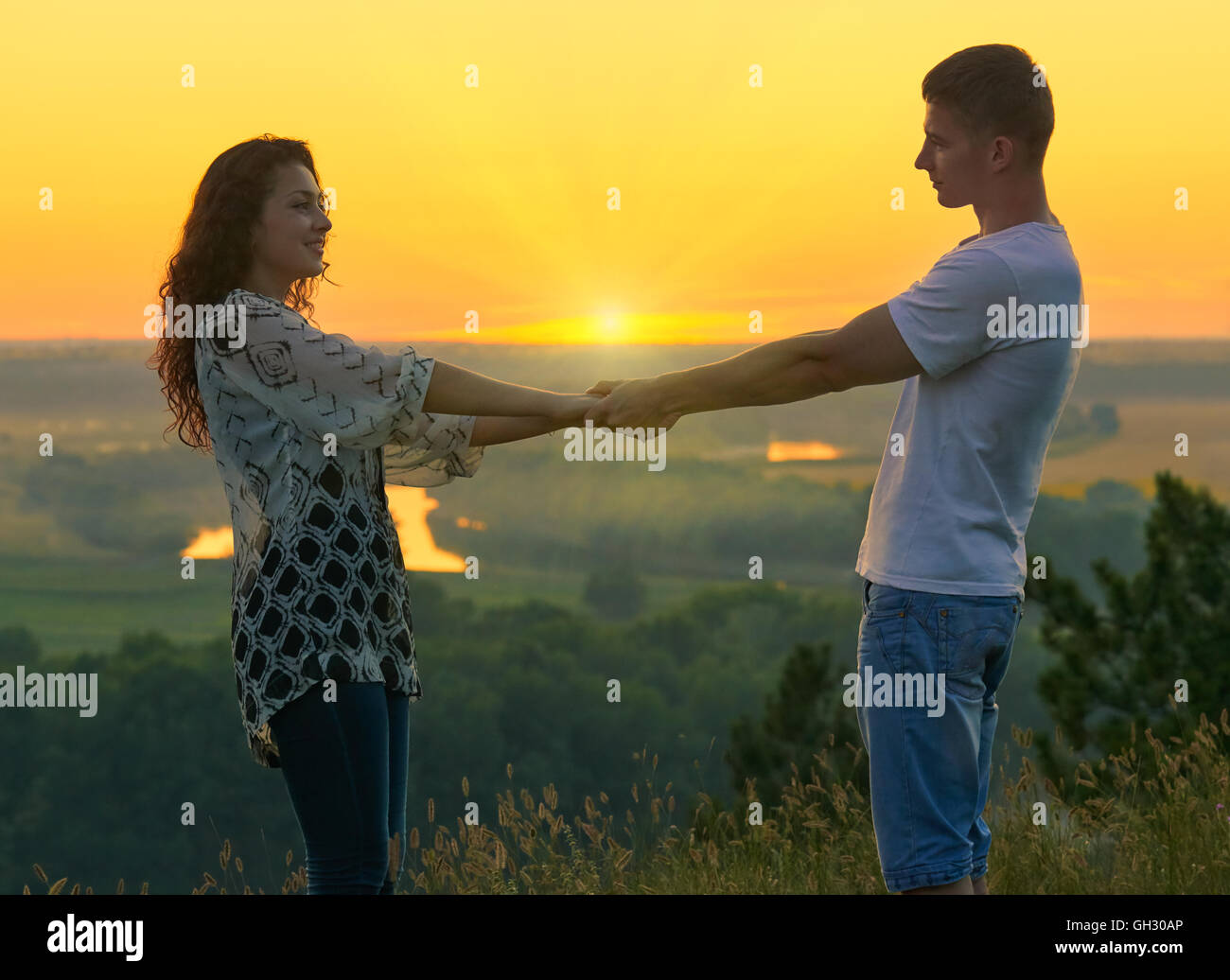 romantic couple holding hands at sunset on outdoor, beautiful landscape ...