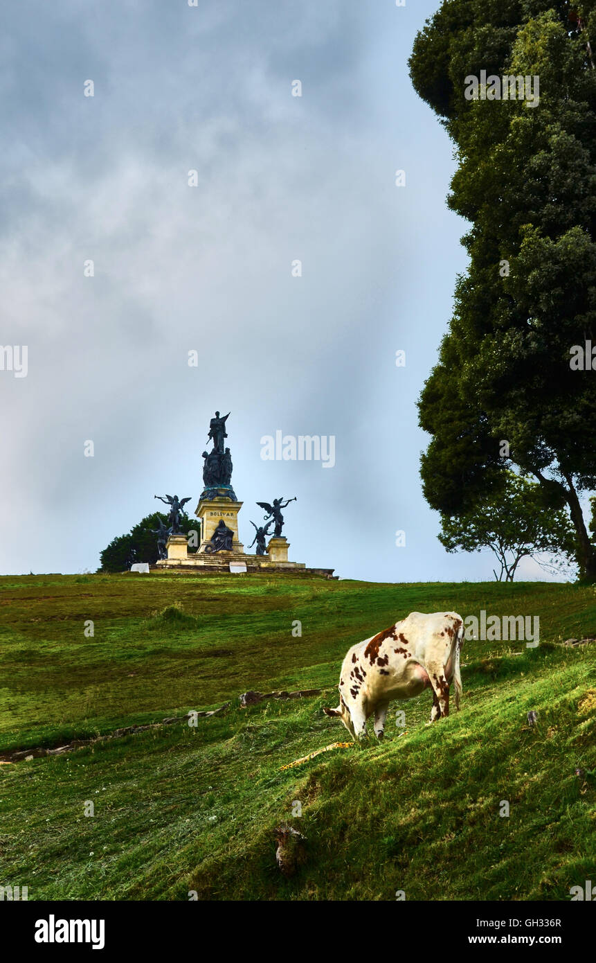 The monument to Simon Bolivar in the Boyaca Field, with a cow eating in ...