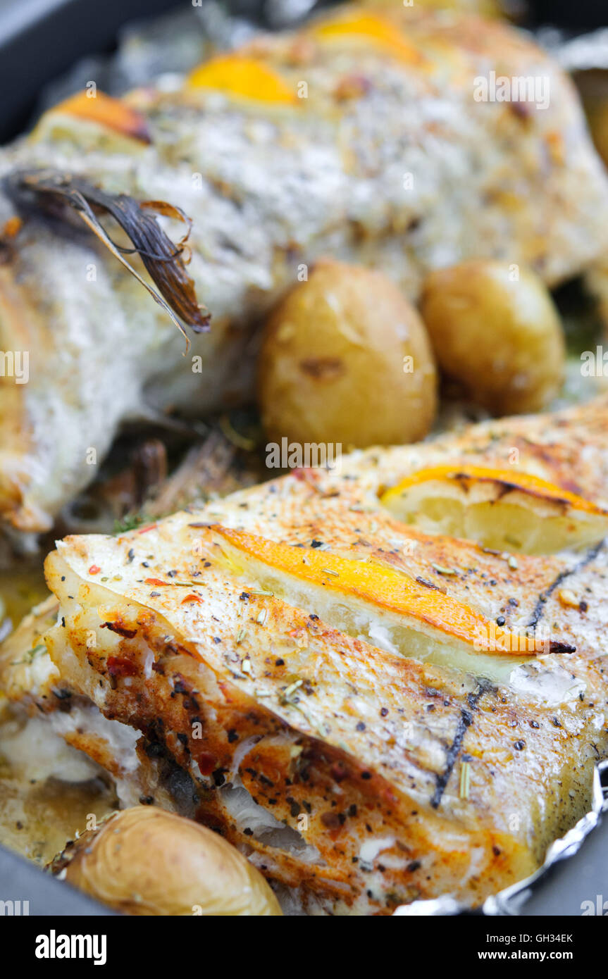 Baked haddock with lemon slices and small potatoes Stock Photo - Alamy