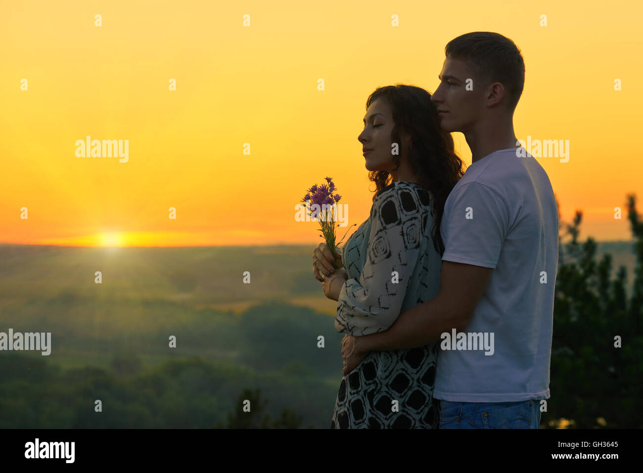 romantic couple look on sun, evening on outdoor, beautiful landscape ...