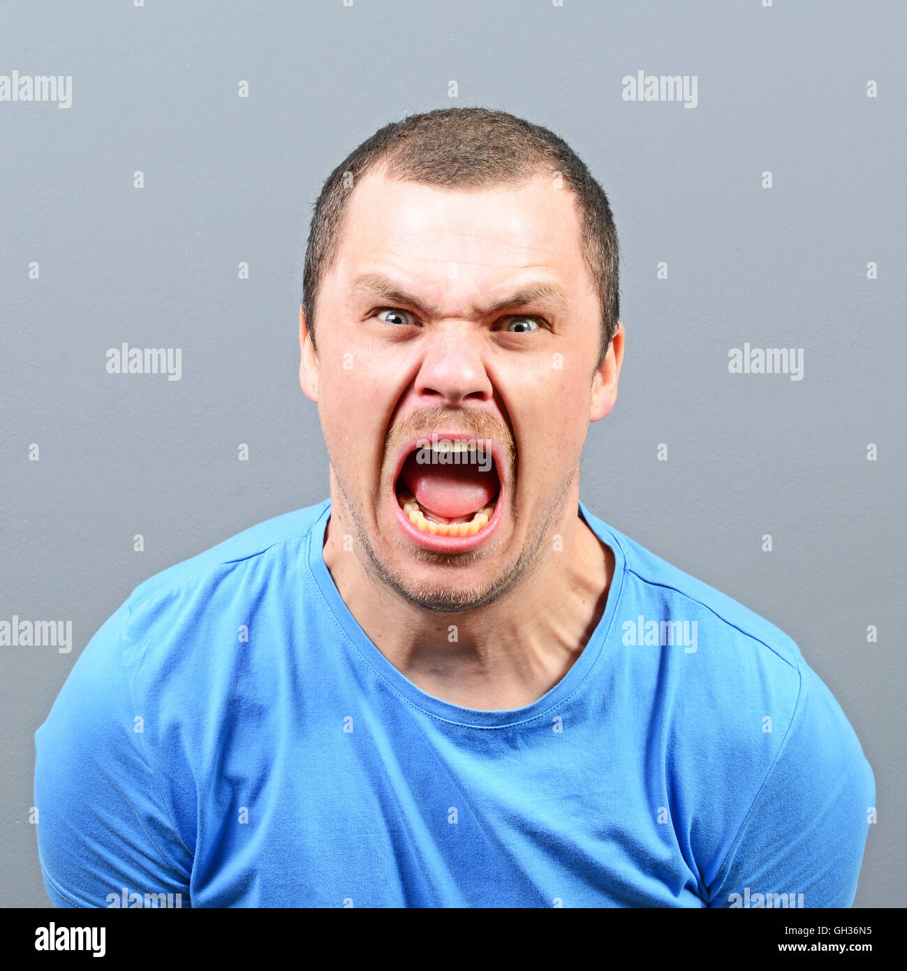 Portrait of a angry man screaming against gray background Stock Photo ...