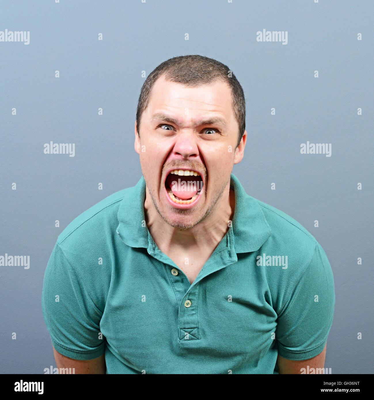 Portrait of a angry man screaming against gray background Stock Photo ...