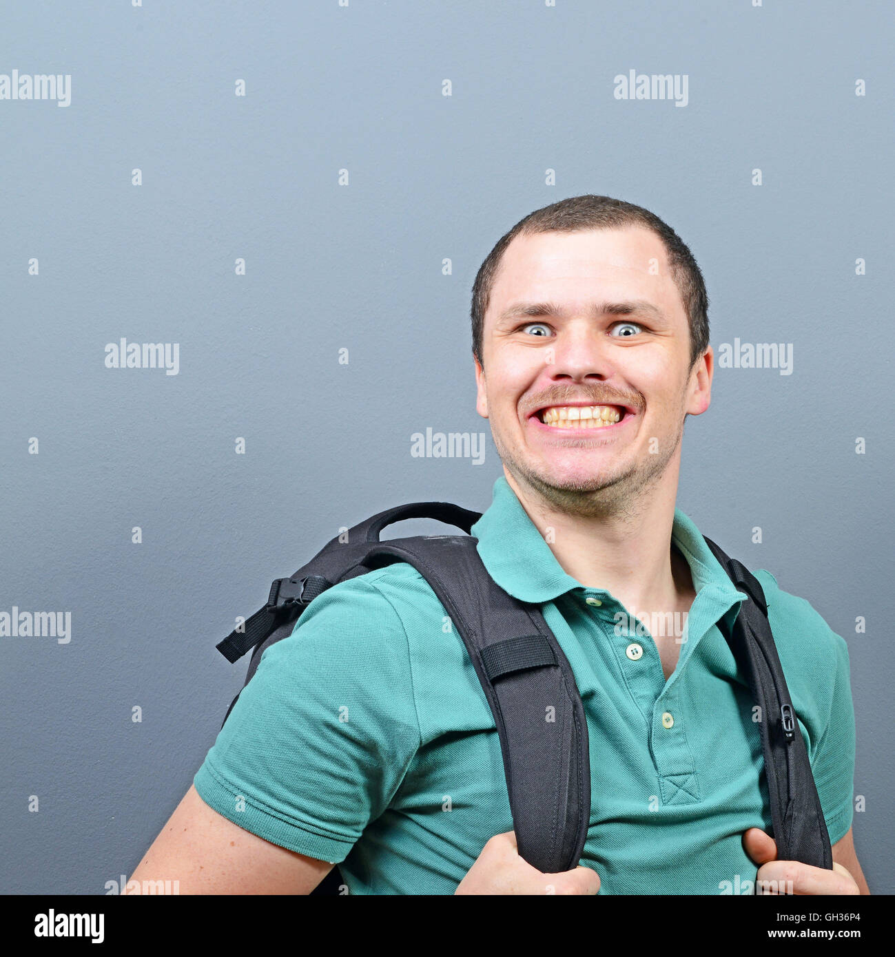 Portrait of a funny man with backpack against gray background Stock ...