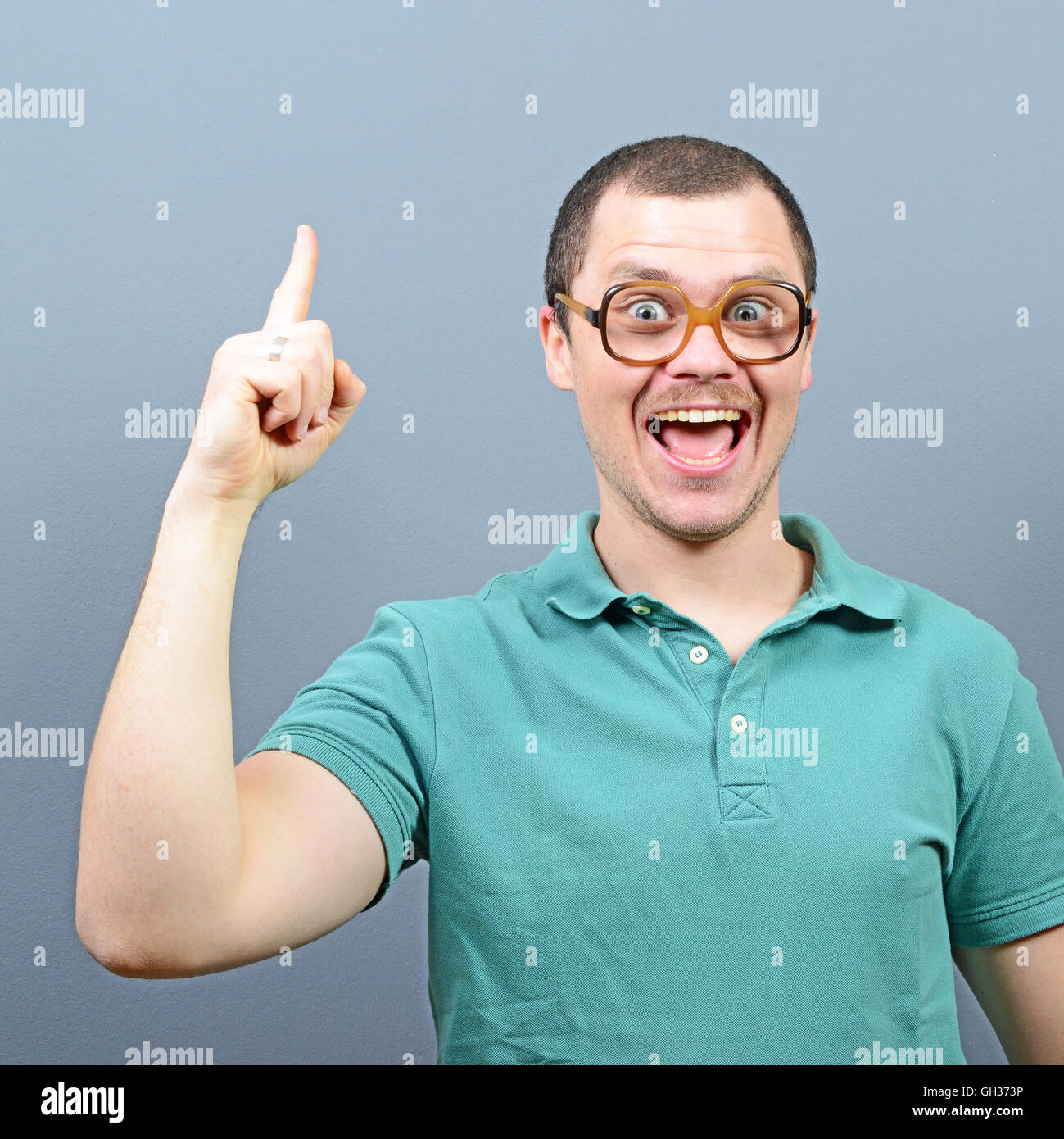 Portrait of funny nerd guy having an idea against gray background Stock ...