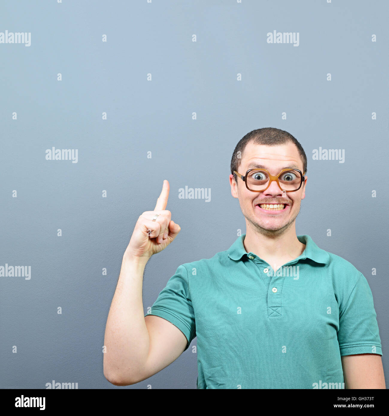 Portrait of funny nerd with big eyes having an idea and showing at ...