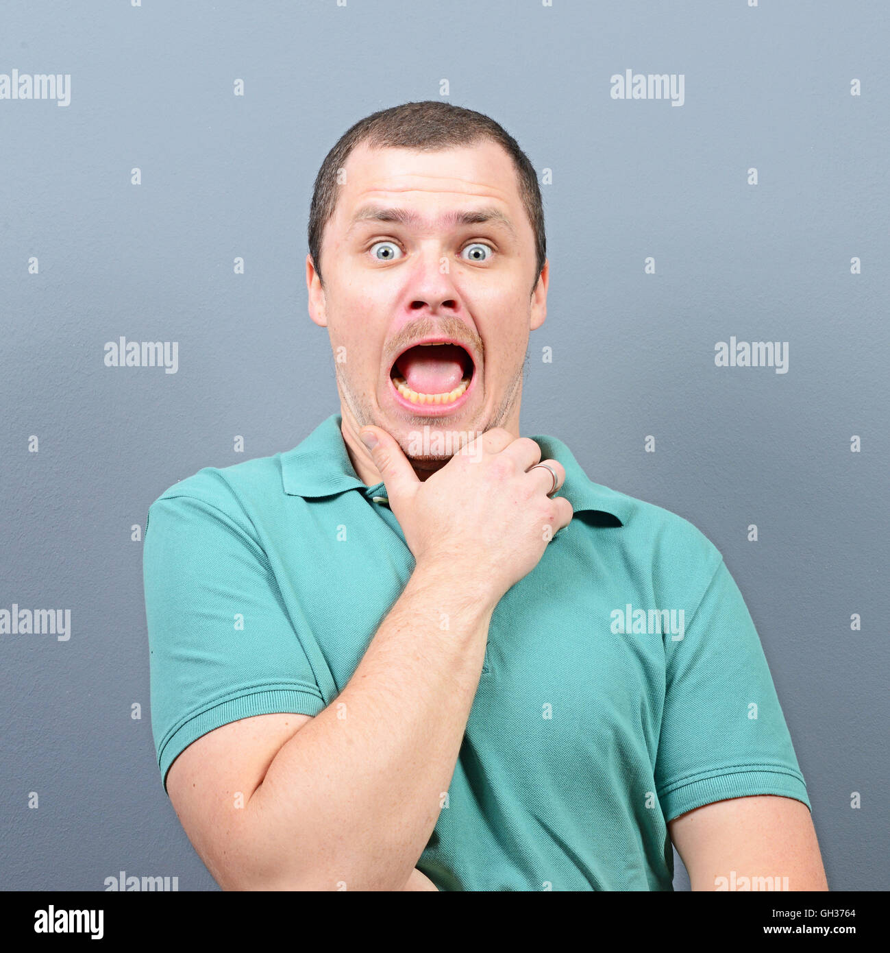 Portrait of shocked man against gray background Stock Photo - Alamy