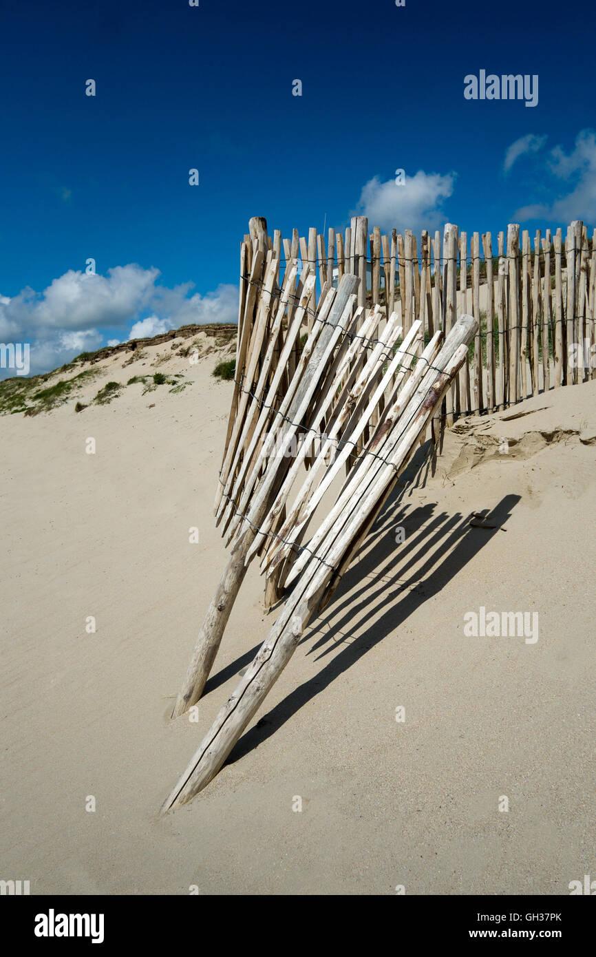 Sandy beach, blue sky with a worn wooden fence in the middle of the ...