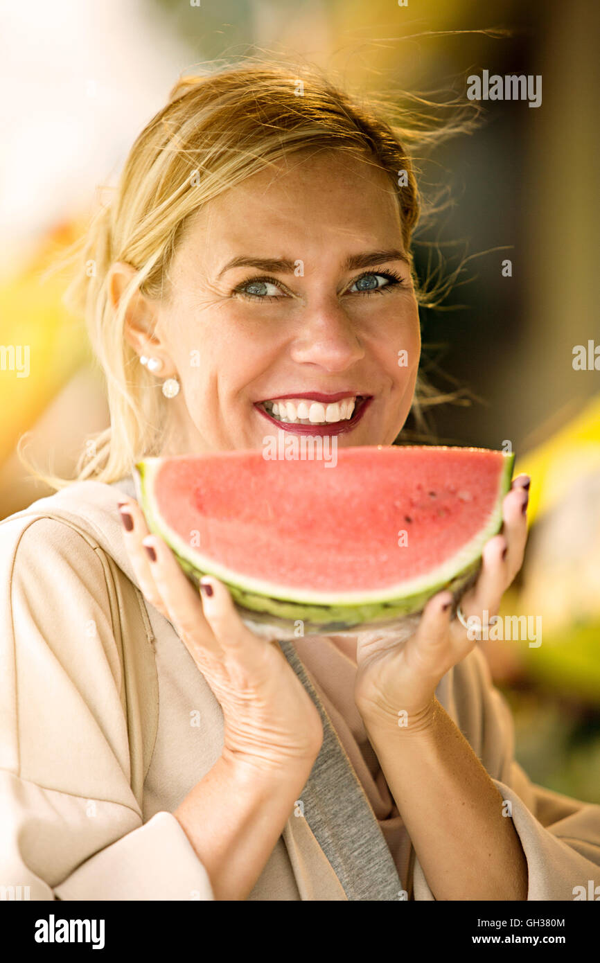 portrait of blond woman holding a melon Stock Photo - Alamy