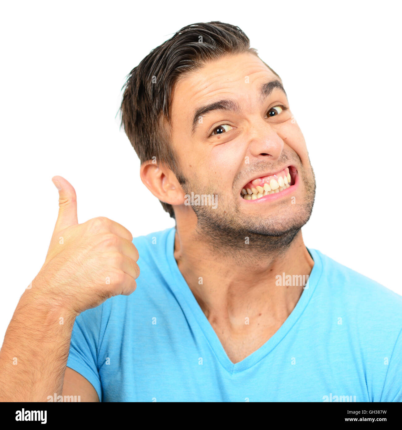 Portrait of with funny expression holding thumbs up against white ...
