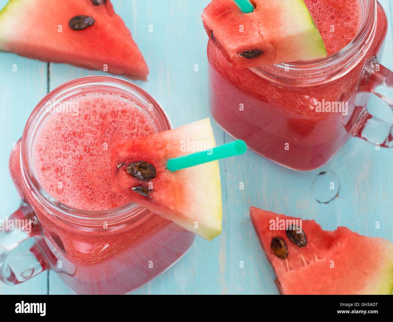 Watermelon smothie and slices on blue background Stock Photo - Alamy