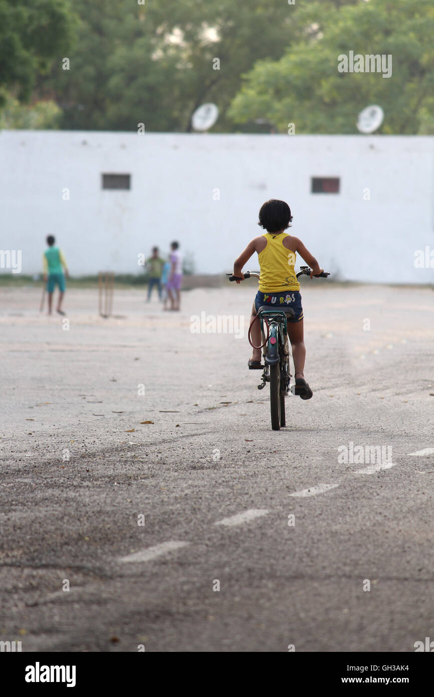 A small Indian girl riding away on her bicycle Stock Photo - Alamy