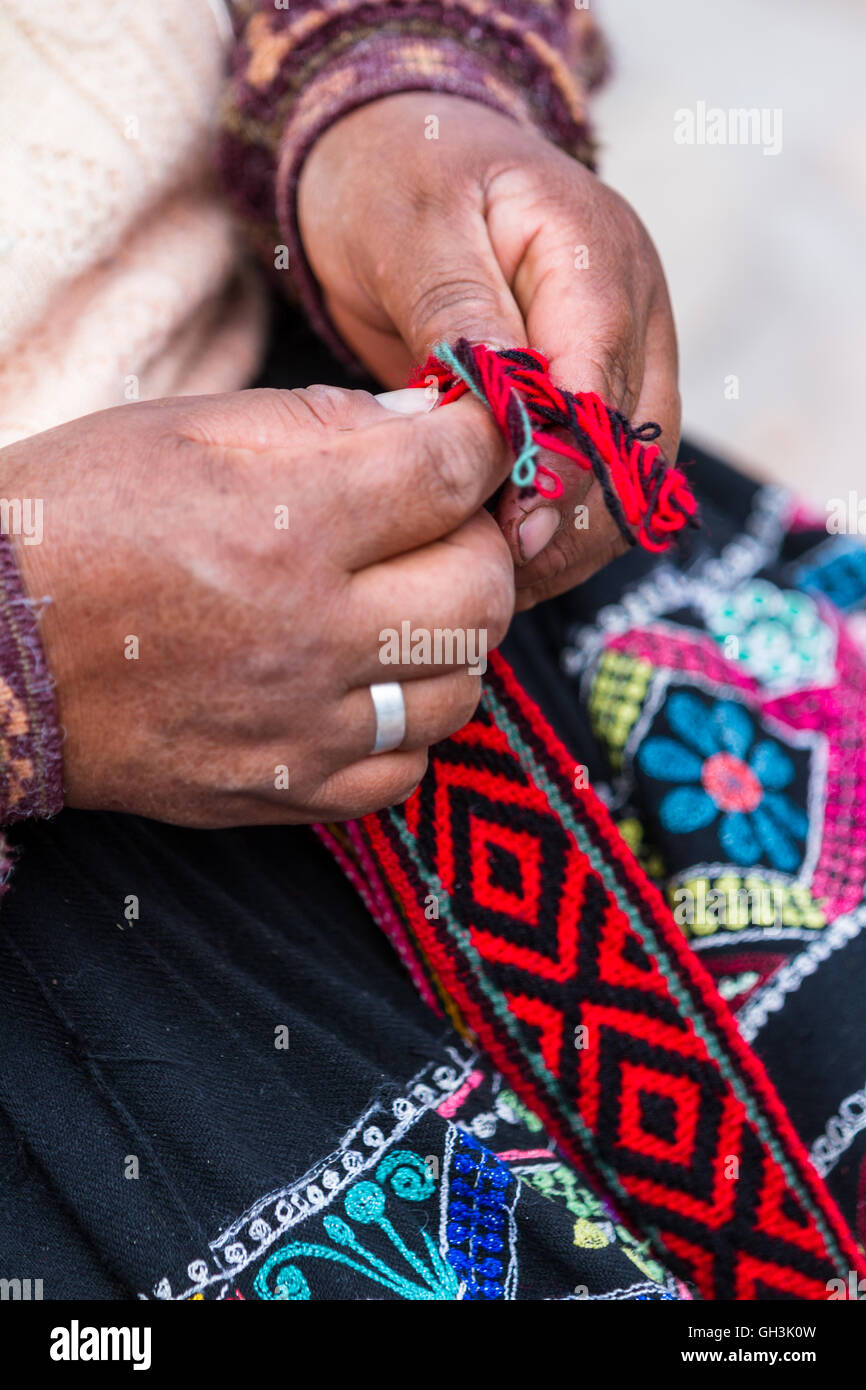 close up of a woman's hands making Peruvian textiles for sale in the ...