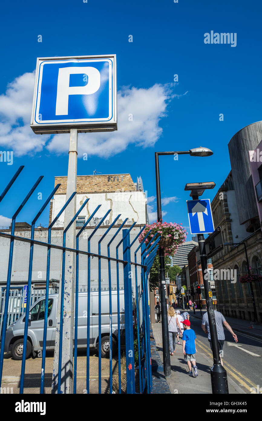 A blue parking sign in a London Street set against a bright blue sky ...