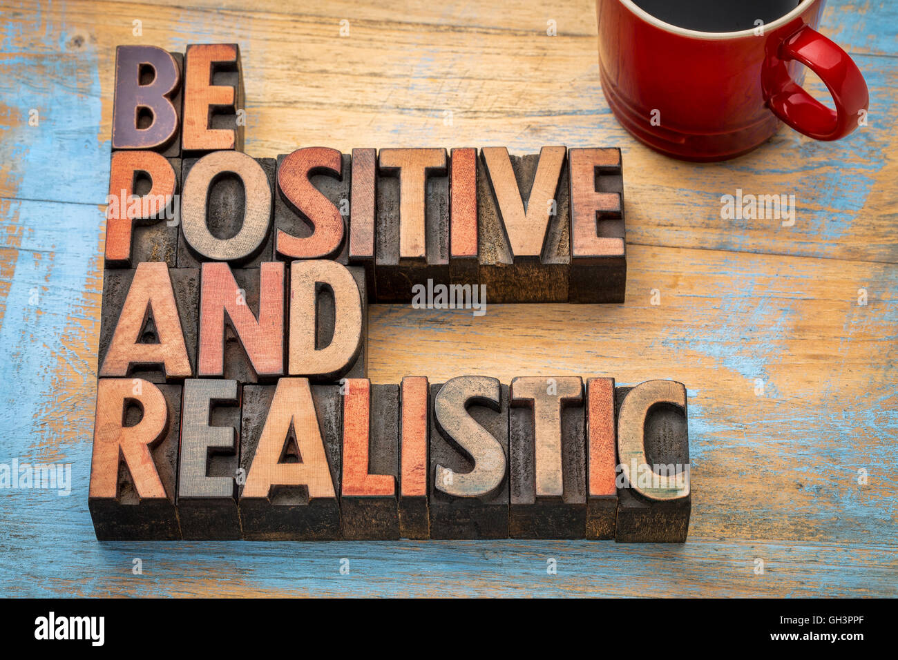 be positive and realistic - motivational text in vintage letterpress ...