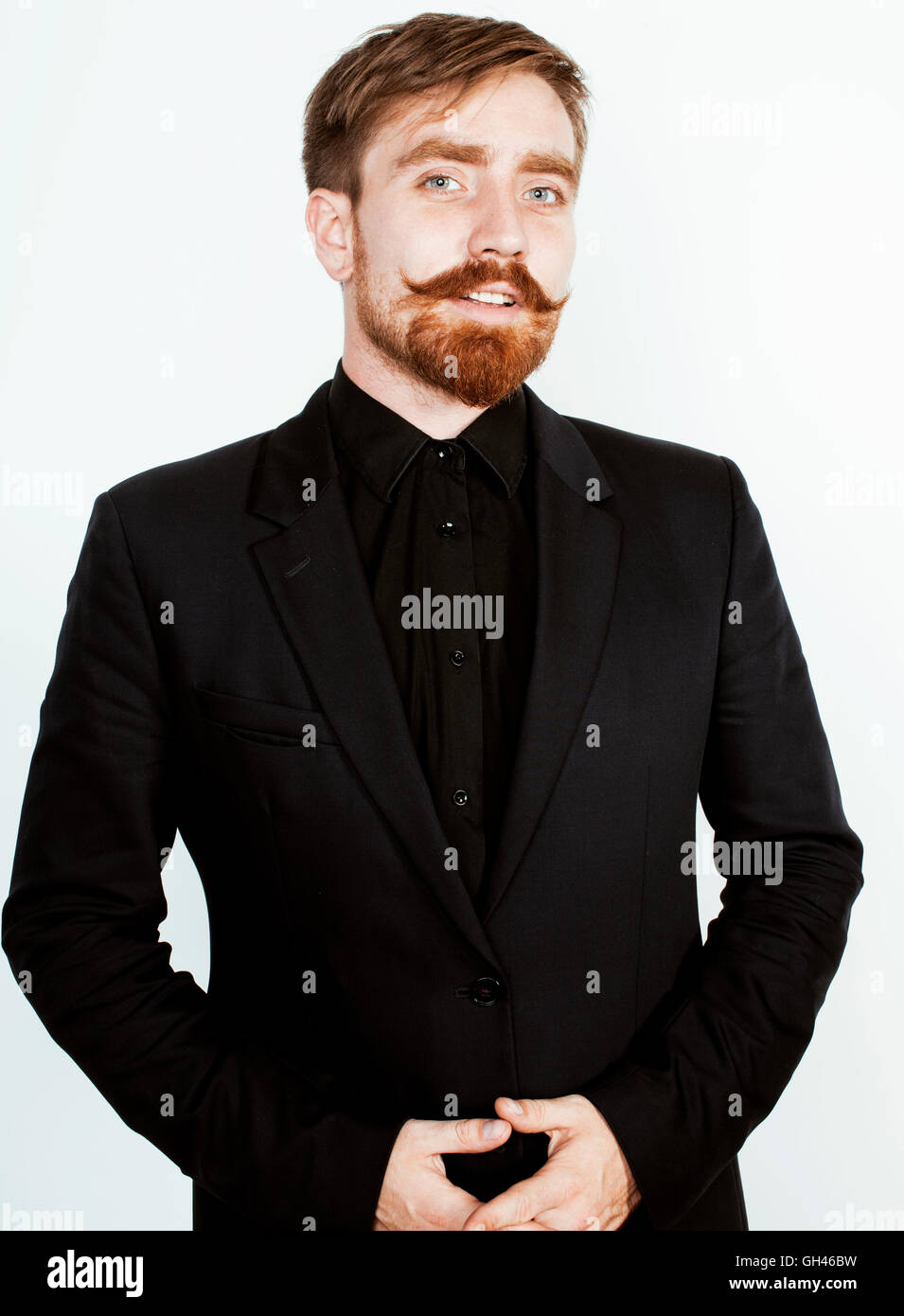 young red hair man with beard and mustache in black suit on white ...