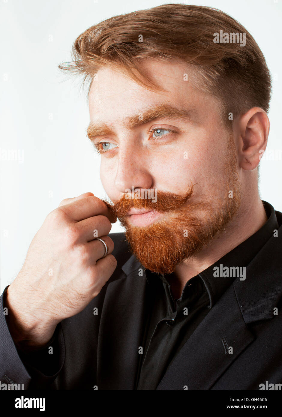 young red hair man with beard and mustache in black suit on white ...