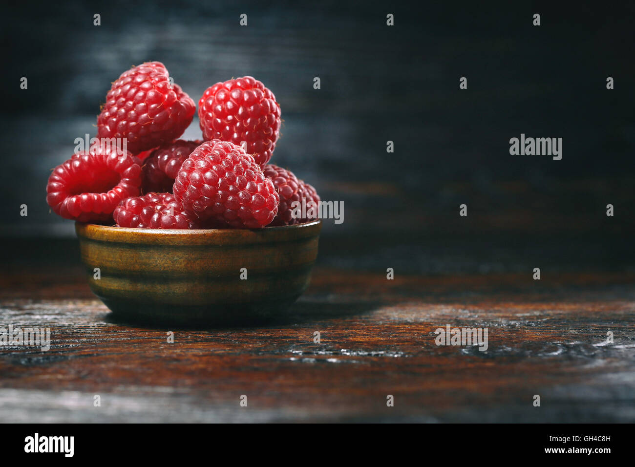 raspberries in bowls on a wooden table Stock Photo - Alamy