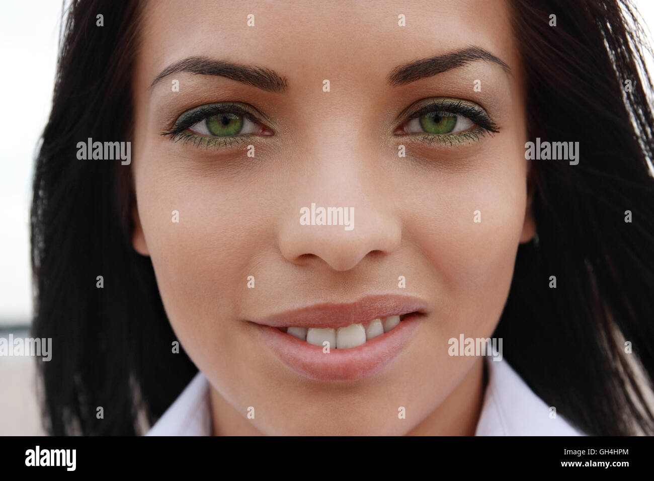 Beautiful green-eyed mulatto girl, looks into the camera close-up ...