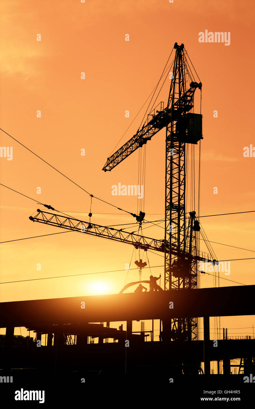 Two construction cranes and construction workers on site Stock Photo ...