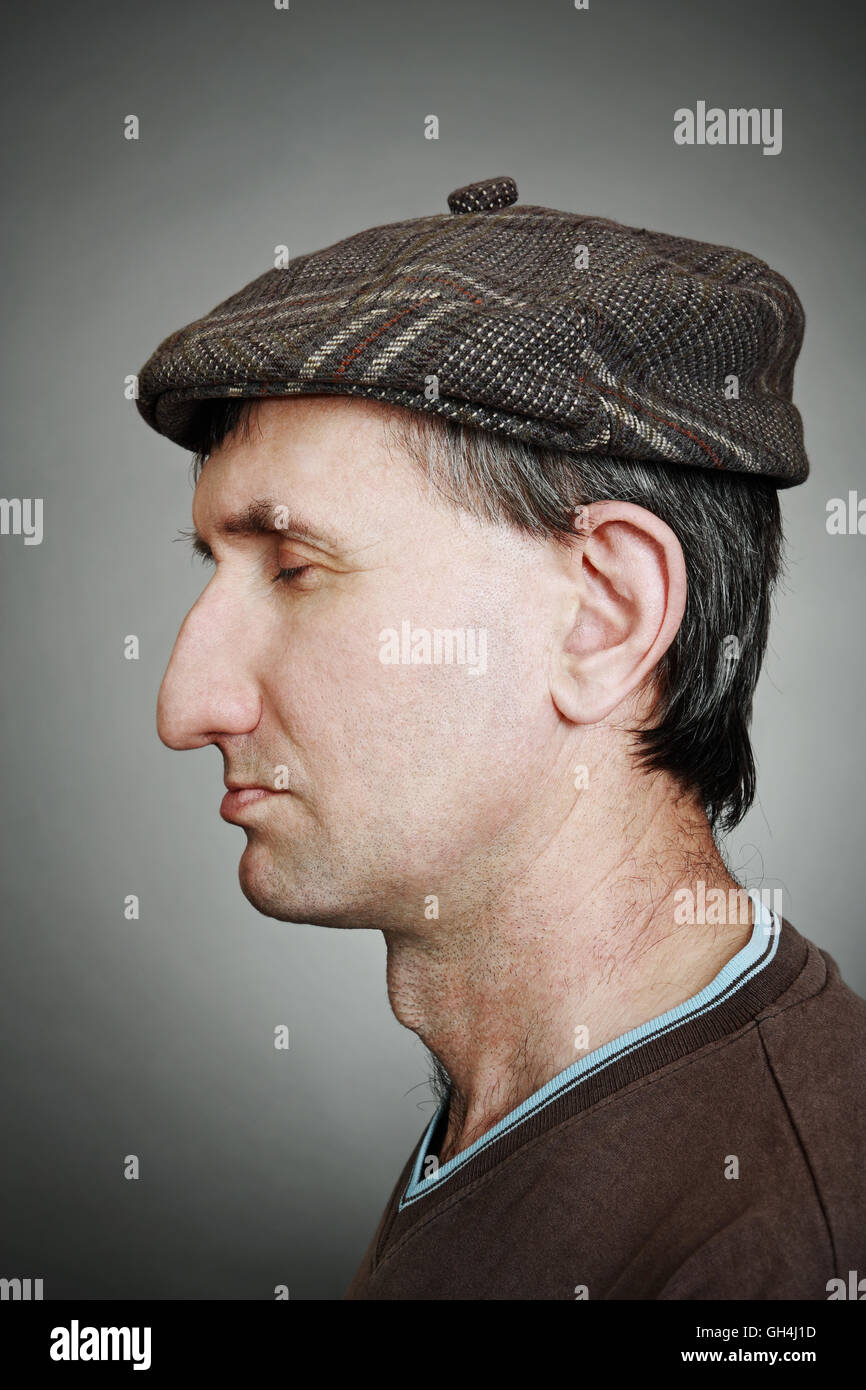 Portrait of a real man in a cap in profile with closed eyes on a gray ...