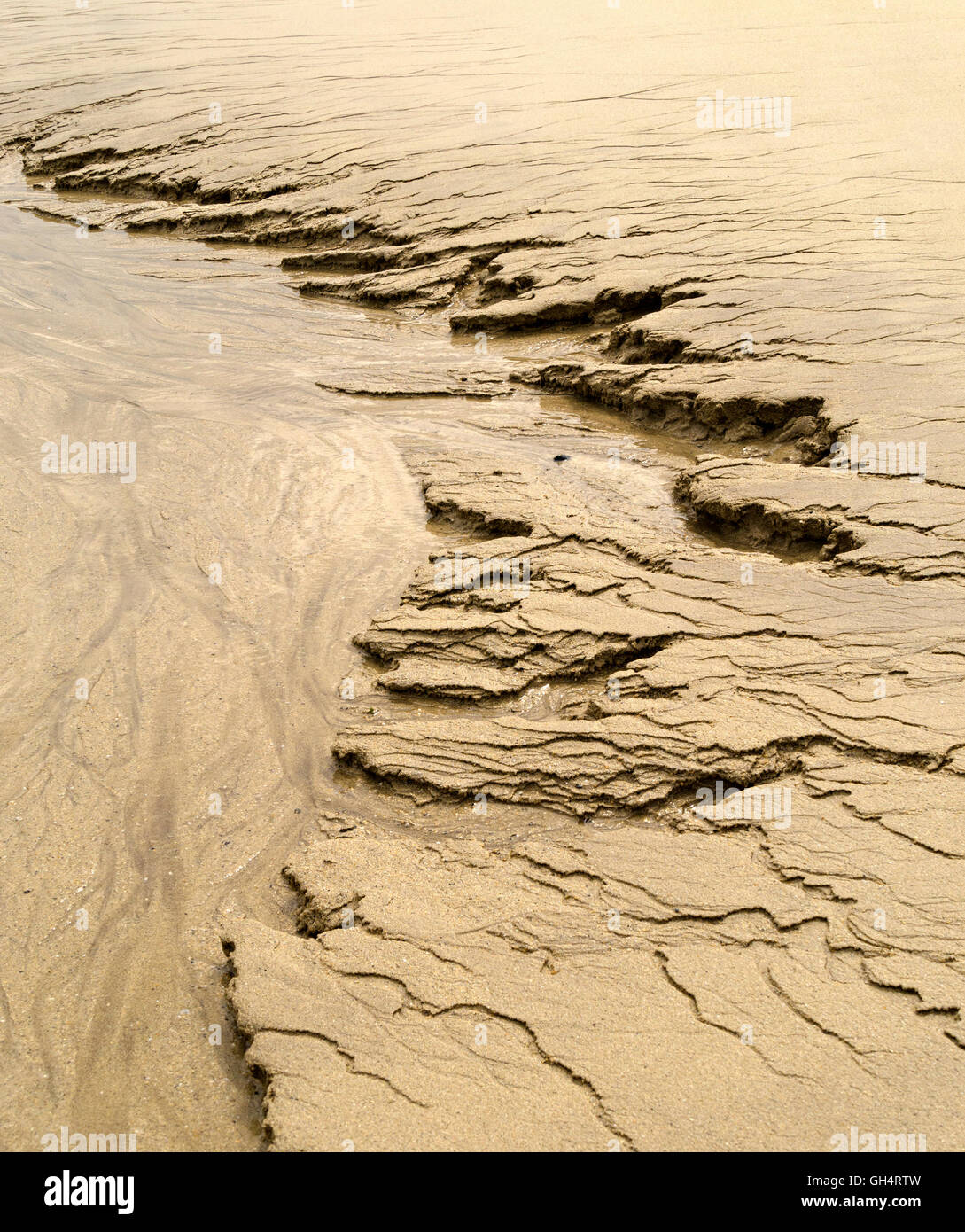Patterns in yellow beach sand caused by water erosion Stock Photo - Alamy