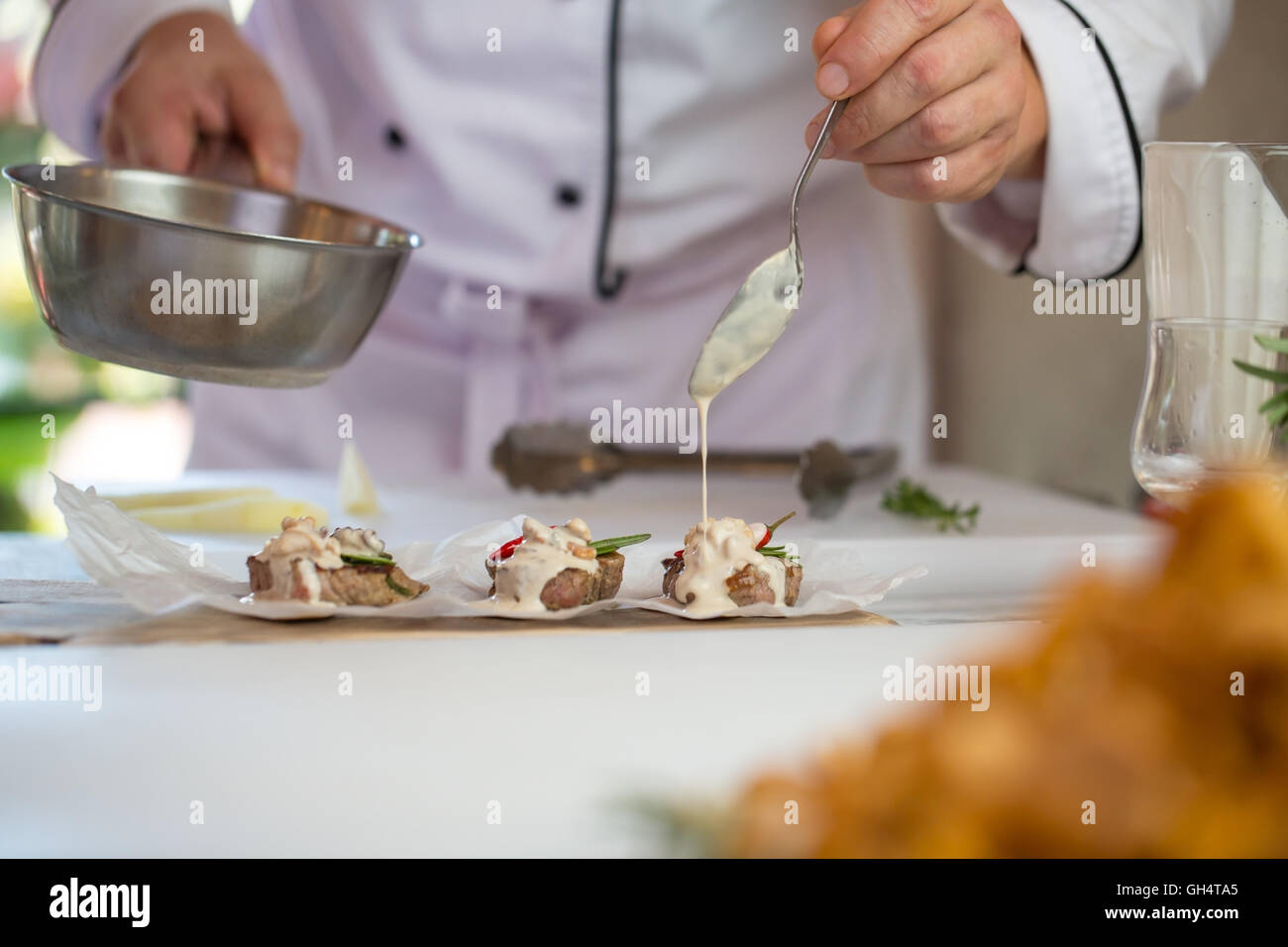 Hand holds spoon over meat Stock Photo - Alamy