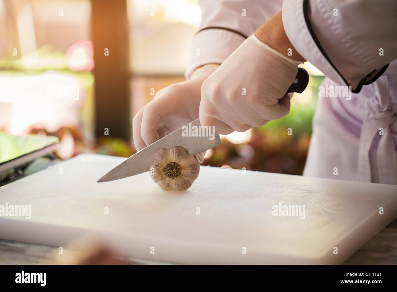 Hand with knife cuts garlic Stock Photo - Alamy