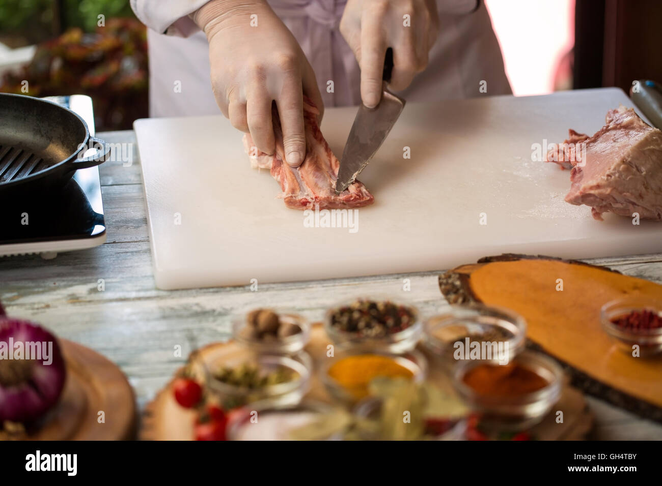 Hand touches meat with knife Stock Photo - Alamy