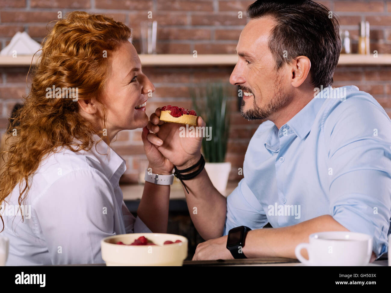 Man looking at woman and holding cake Stock Photo - Alamy