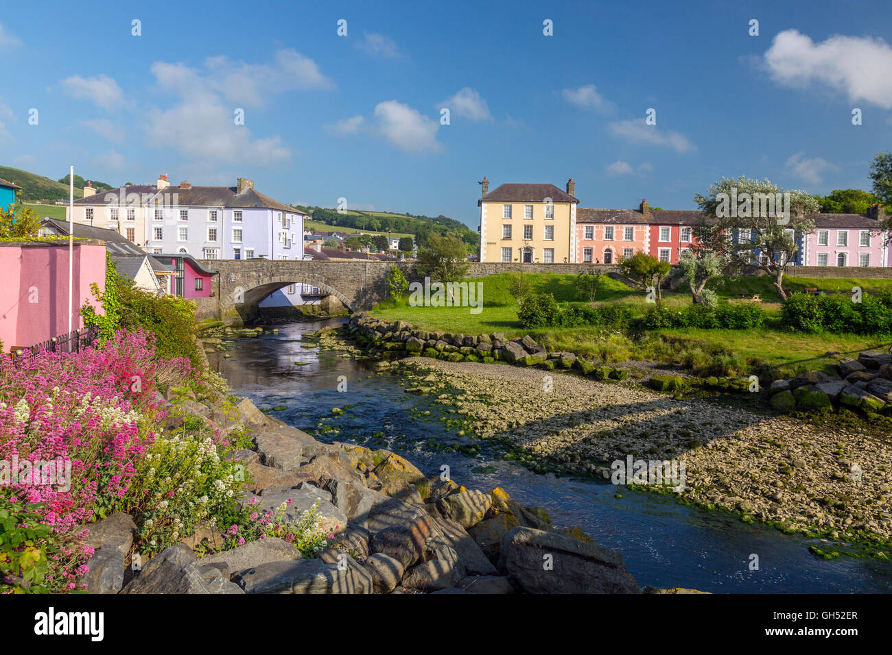 Colourful terraces of houses overlook the River Aeron as it enters the ...