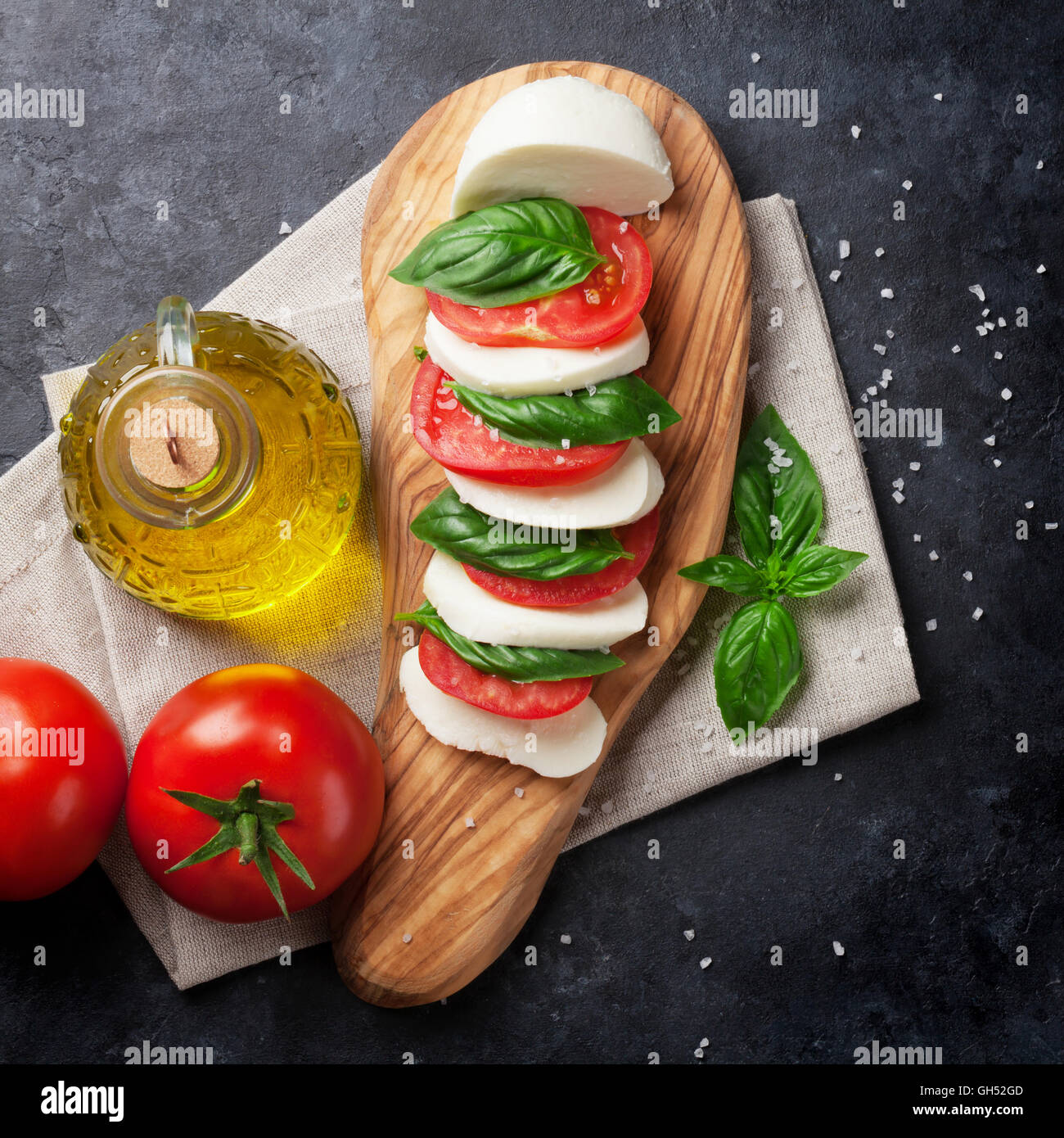 Caprese salad. Mozzarella cheese, tomatoes and basil herb leaves on ...