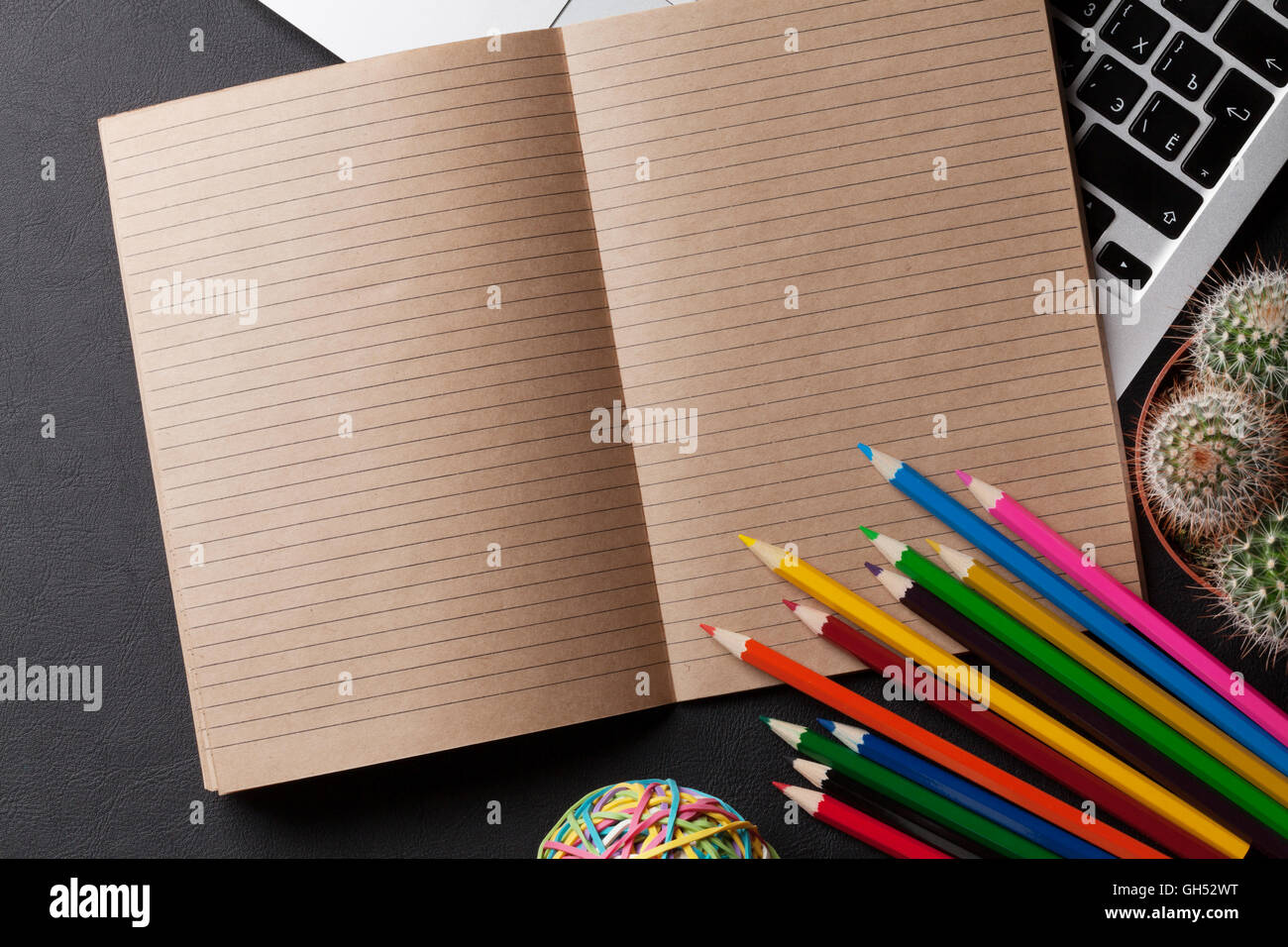 Office desk with laptop pc, notepad and supplies over leather texture ...