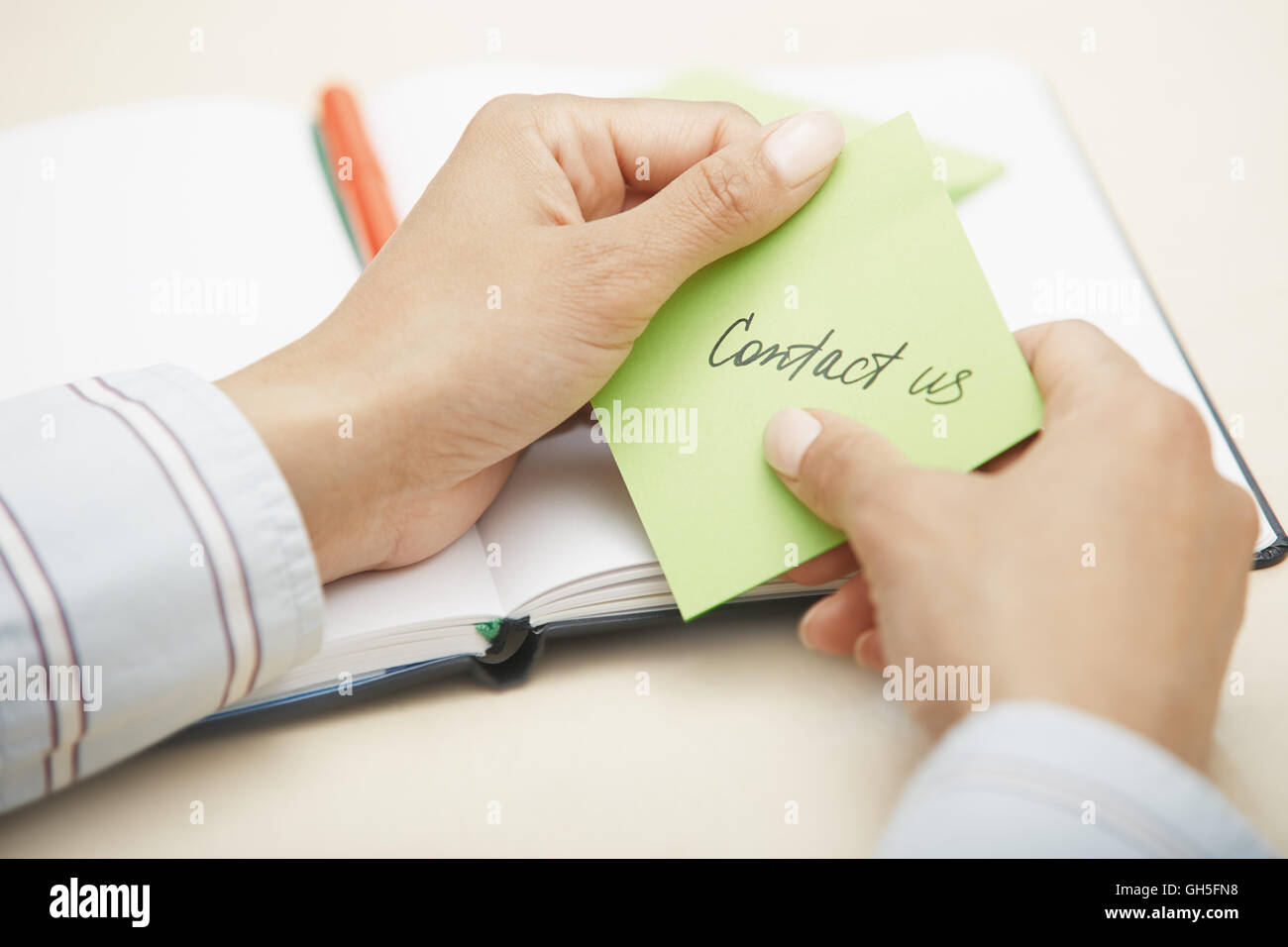 Hands holding sticky note with Contact us text Stock Photo - Alamy