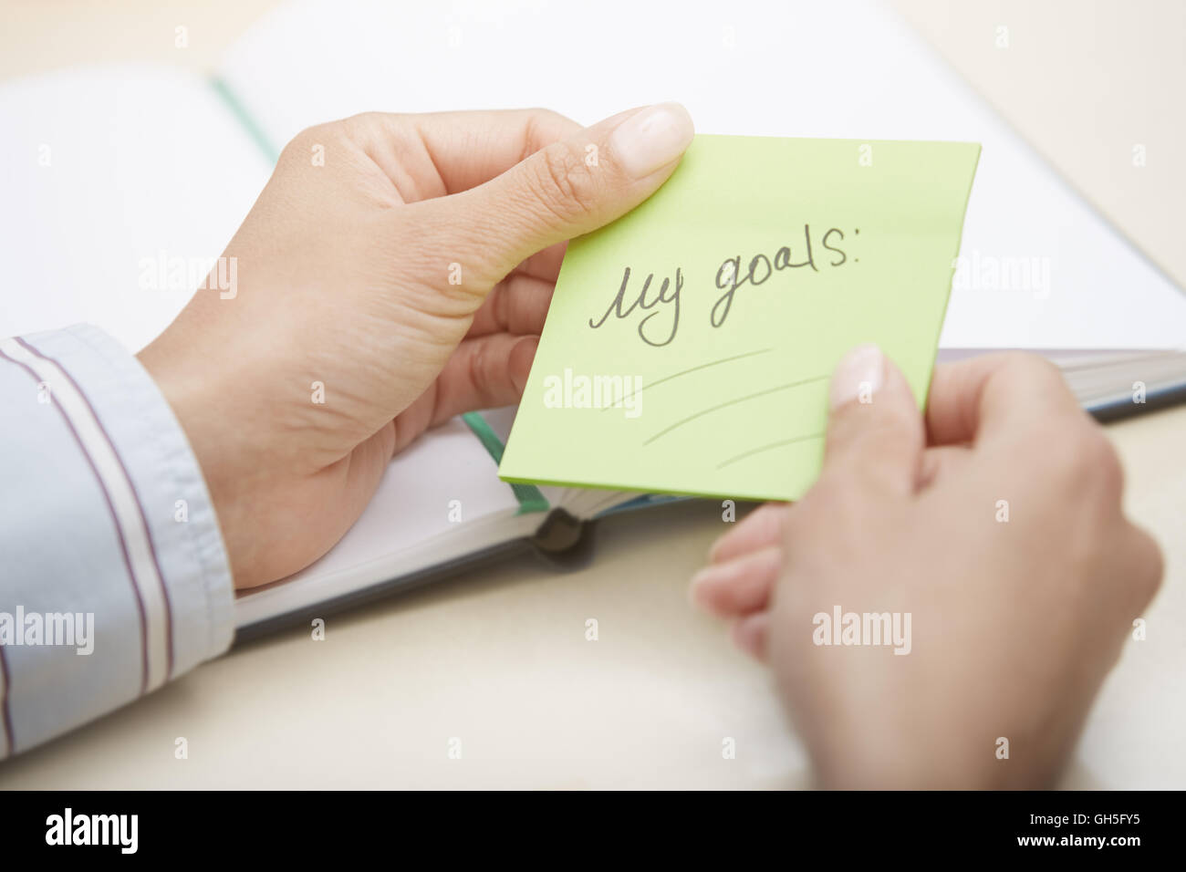 Hands holding green sticky note with planning of objectives Stock Photo ...