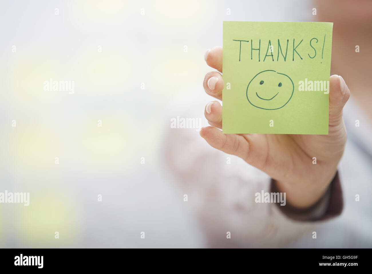 Woman holding sticky note with Thanks text Stock Photo - Alamy