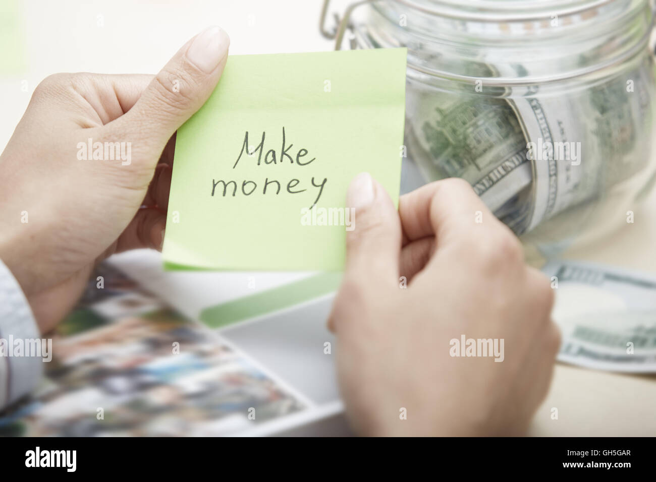 Hands of businessperson holding adhesive note with Make money text ...