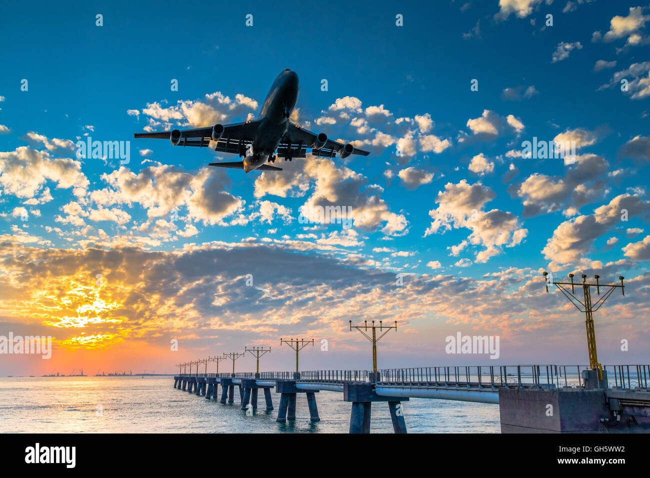 Airplane landing at sunset Stock Photo - Alamy